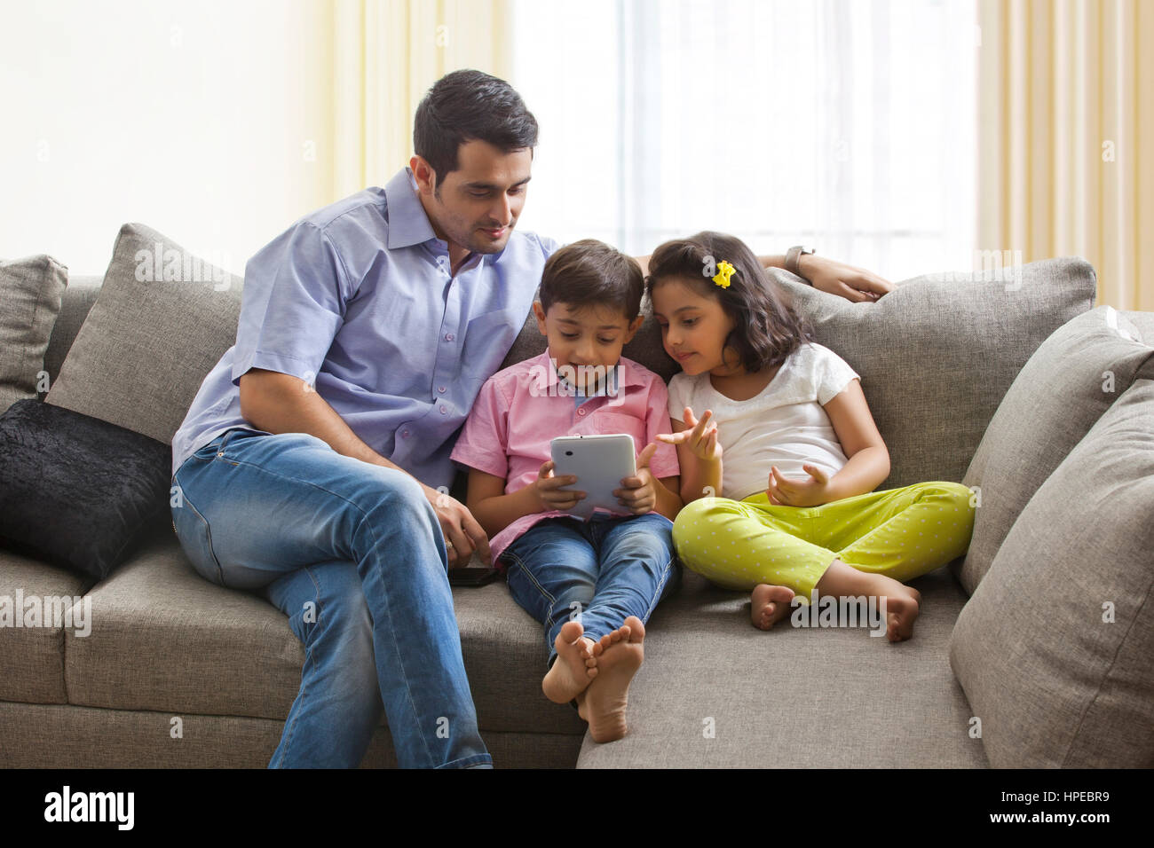 Father looking at children using digital tablet Stock Photo - Alamy