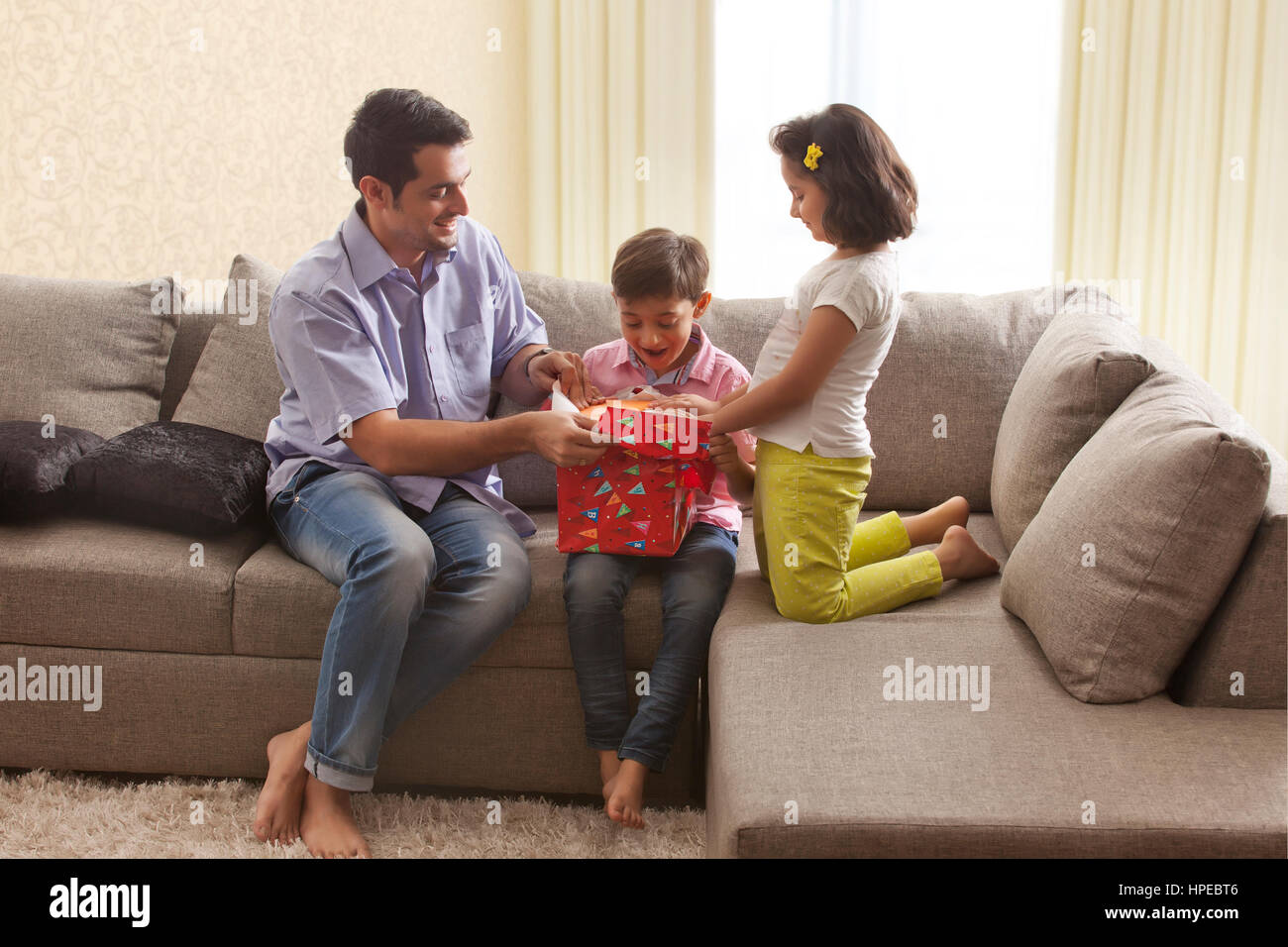 Father and children opening gift Stock Photo - Alamy