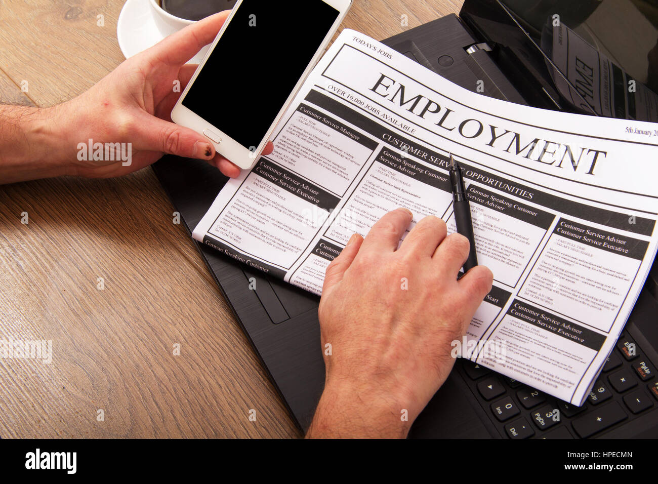 Searching for a new job or employment in a newspaper Stock Photo - Alamy