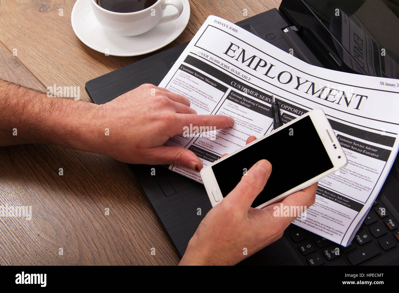 Searching for a new job or employment in a newspaper Stock Photo - Alamy