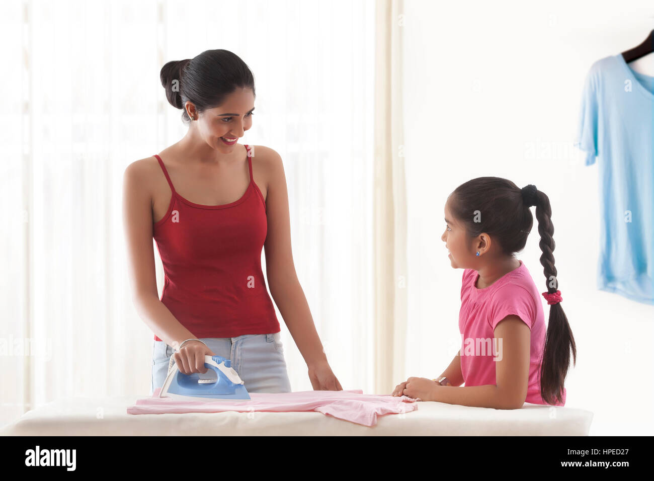 Mother and daughter ironing clothes Stock Photo - Alamy