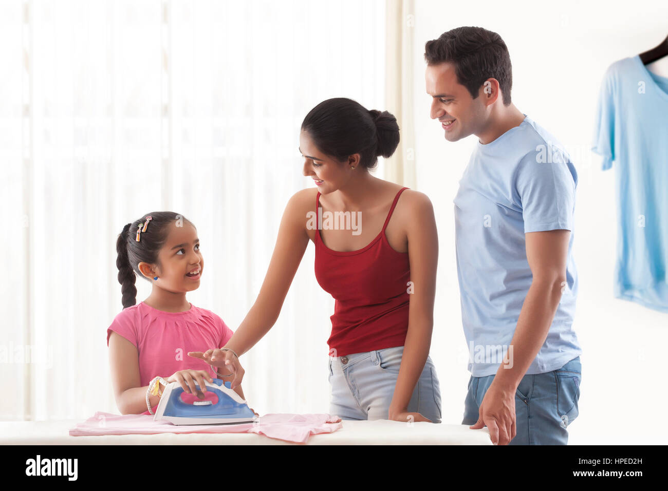 Parents teaching ironing to their daughter Stock Photo - Alamy