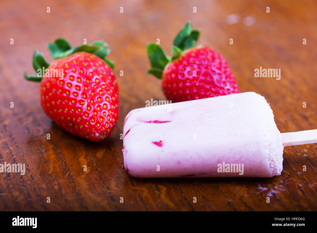 Homemade strawberry ice lolly on a rustic background Stock Photo - Alamy