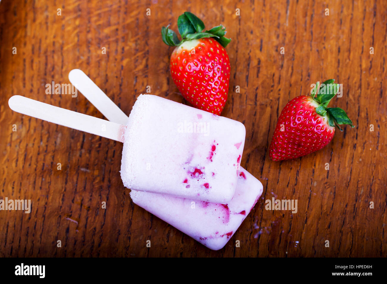 Homemade strawberry ice lolly on a rustic background Stock Photo - Alamy