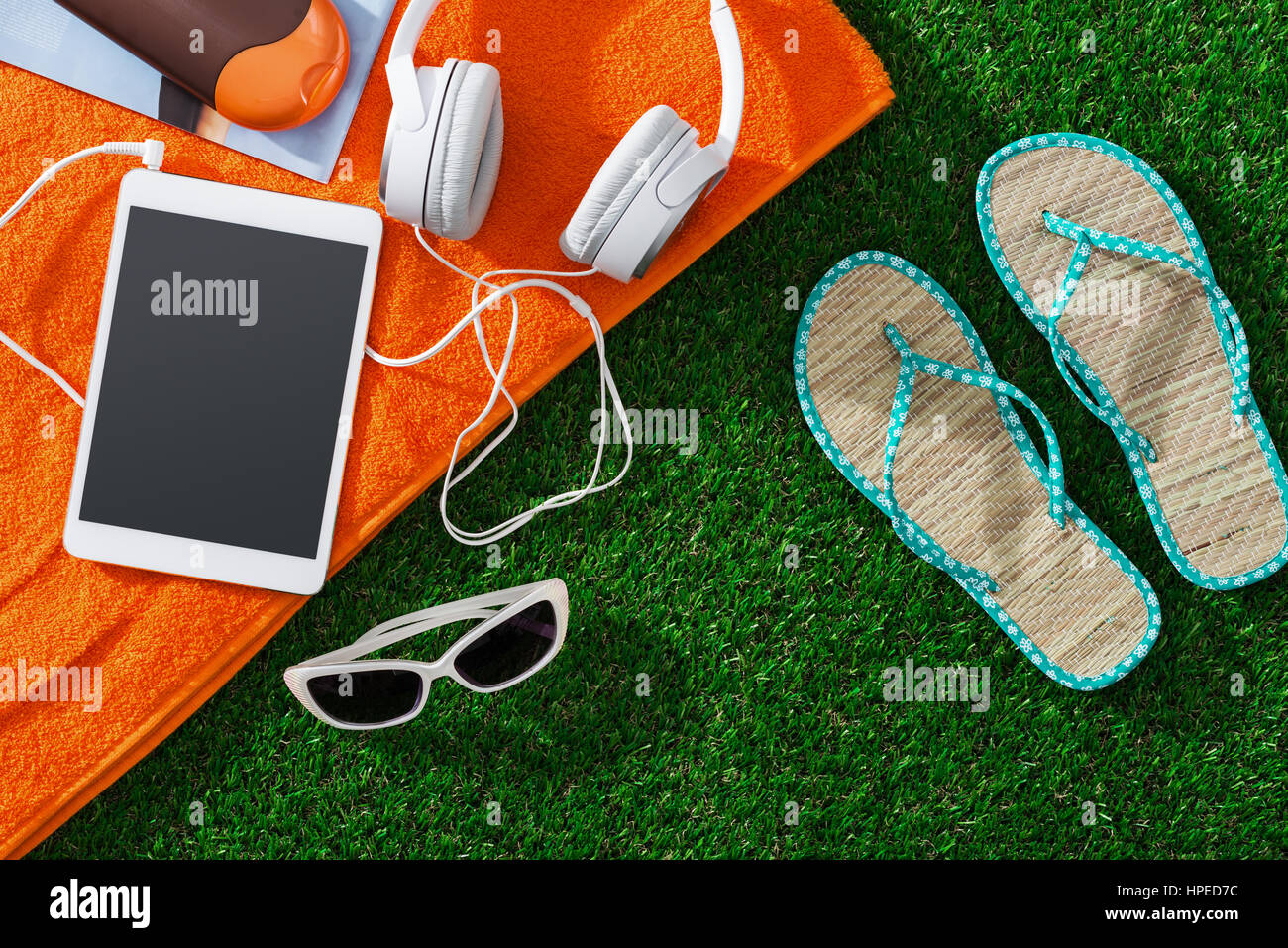 Sunglasses, digital tablet, headphones and towel: summertime ...