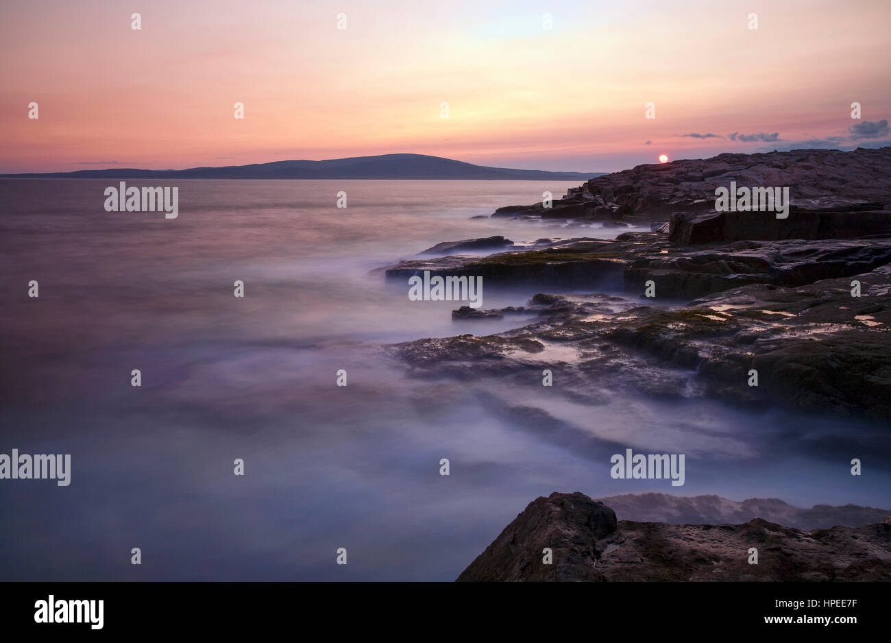 The sun sets against a rocky coast at Schoodic Point in Acadia National ...