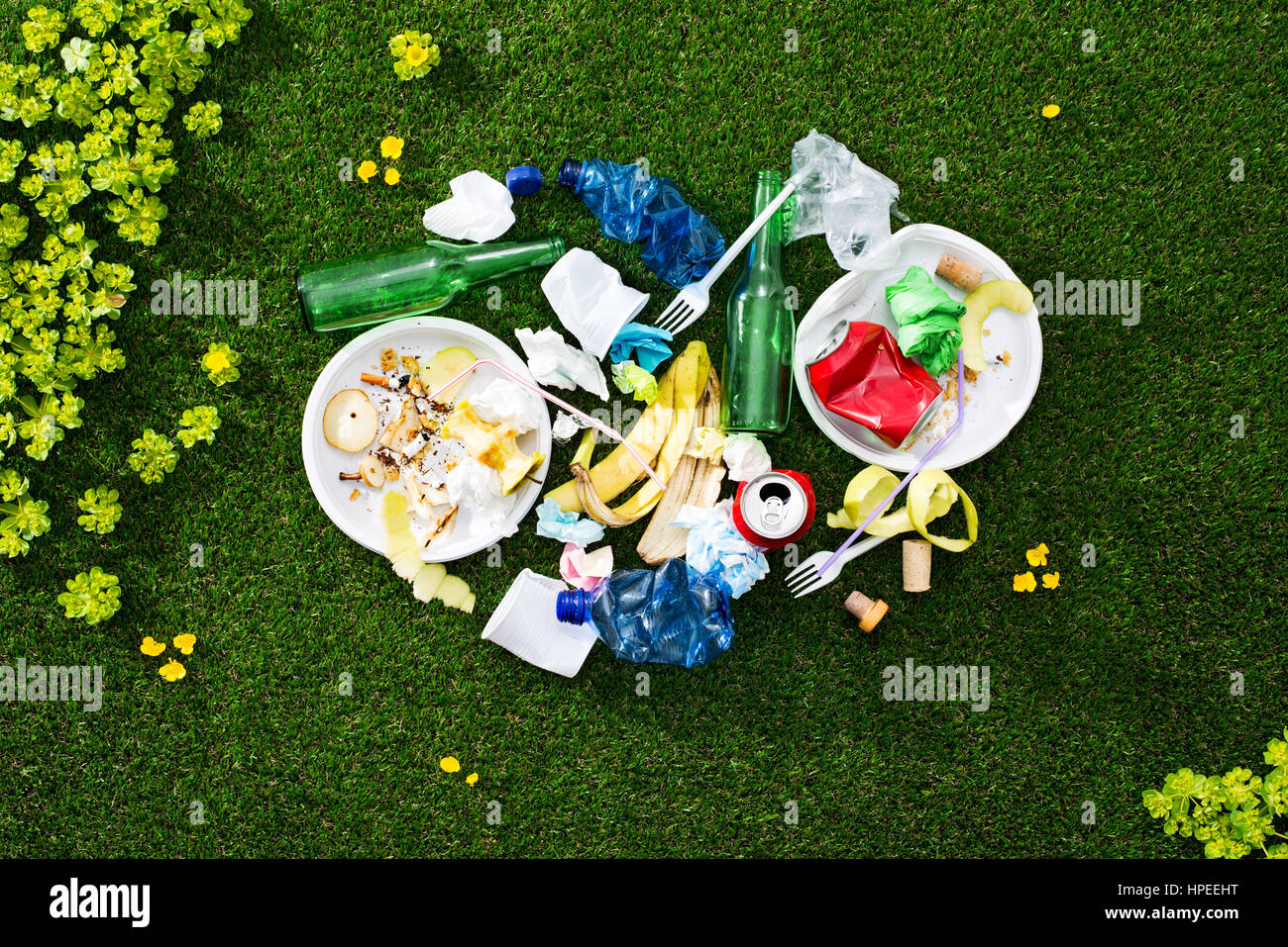 Load of mixed rubbish left on the grass after a picnic, environmental ...