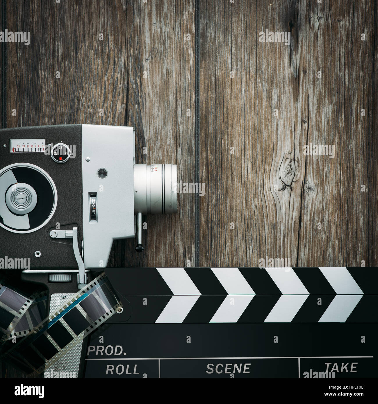 Vintage film camera, filmstrip and clapper board on a wooden desktop ...