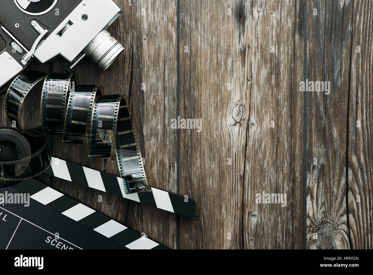 Vintage film camera, filmstrip and clapper board on a wooden desktop ...