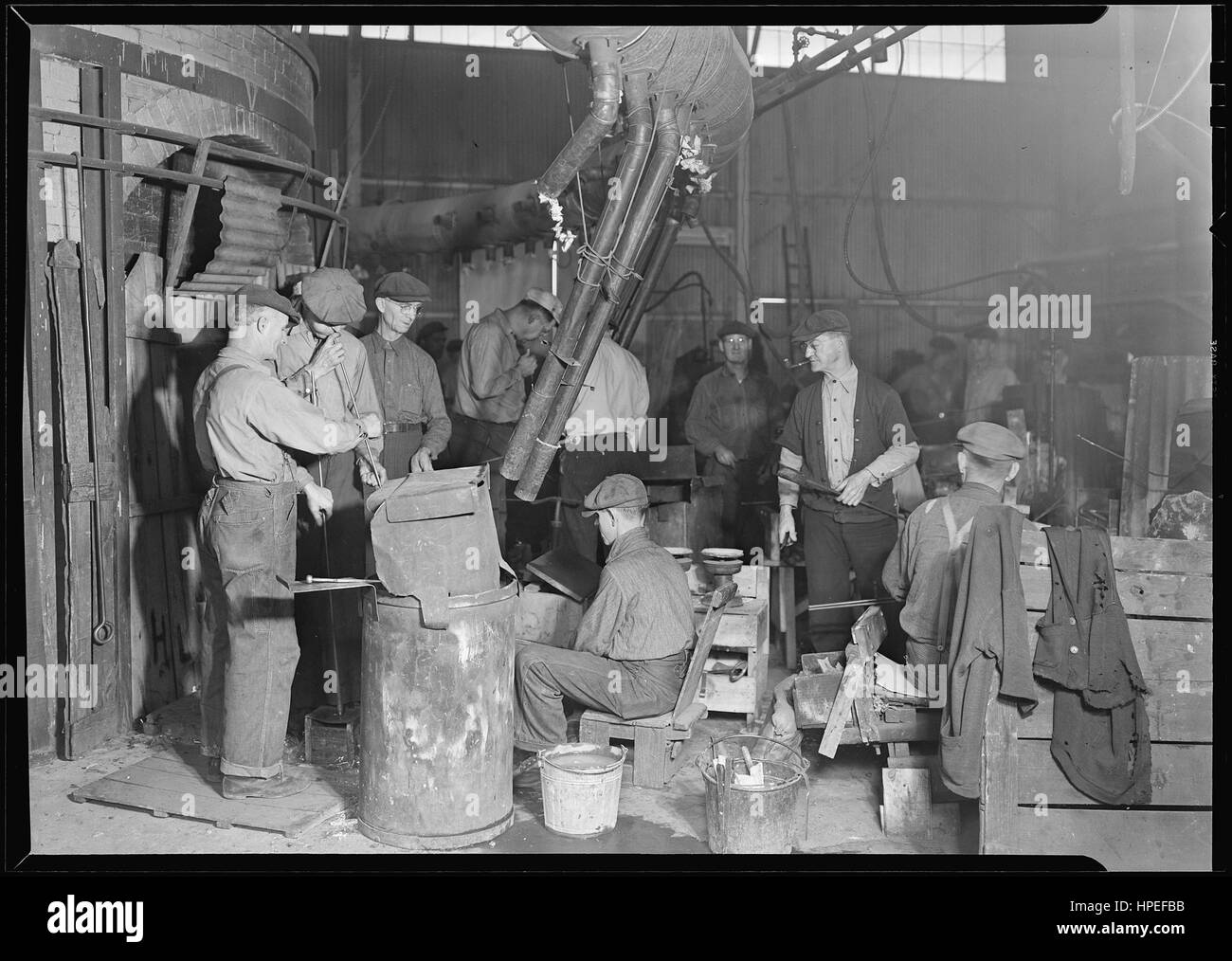 Photograph of laborers in a glass shop working together to produce ...
