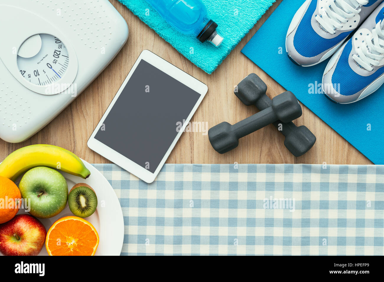 Healthy food, sports equipment, weight scale and digital tablet on a ...
