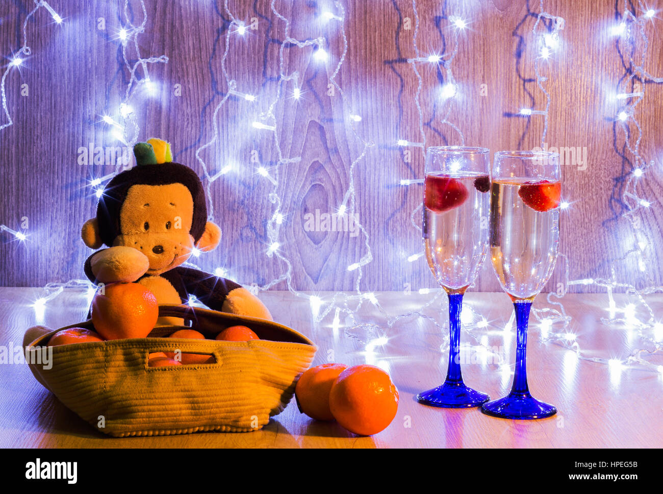 funny monkey toy with oranges under the lights with champagne glass ...