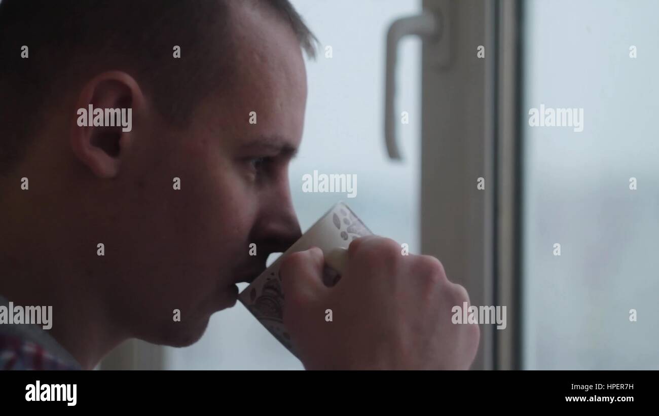 Sad, depressed man drinking tea by the window in home Stock Photo - Alamy