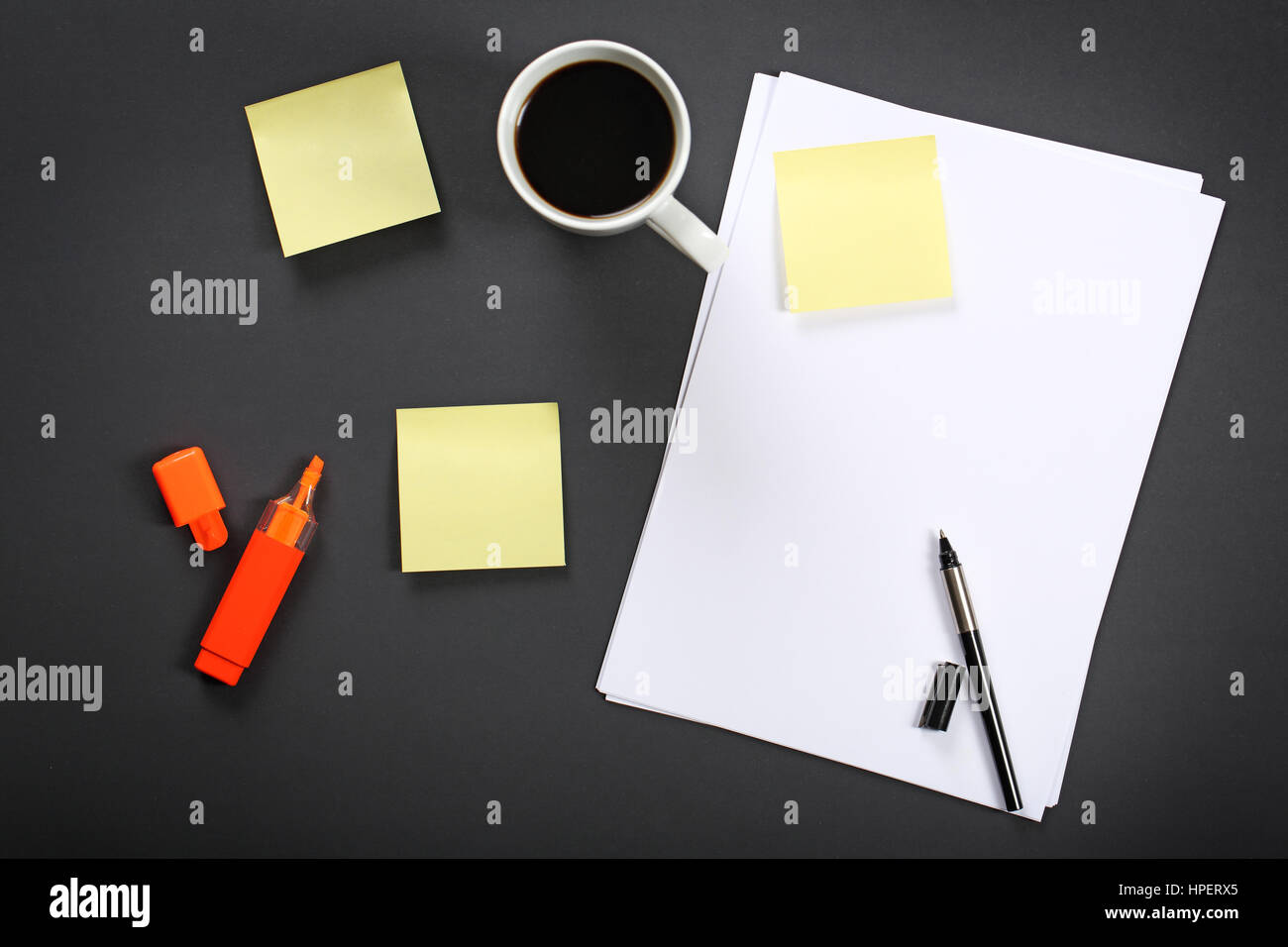 Blank sheet of paper, yellow sticky notes and pen on bright wooden ...