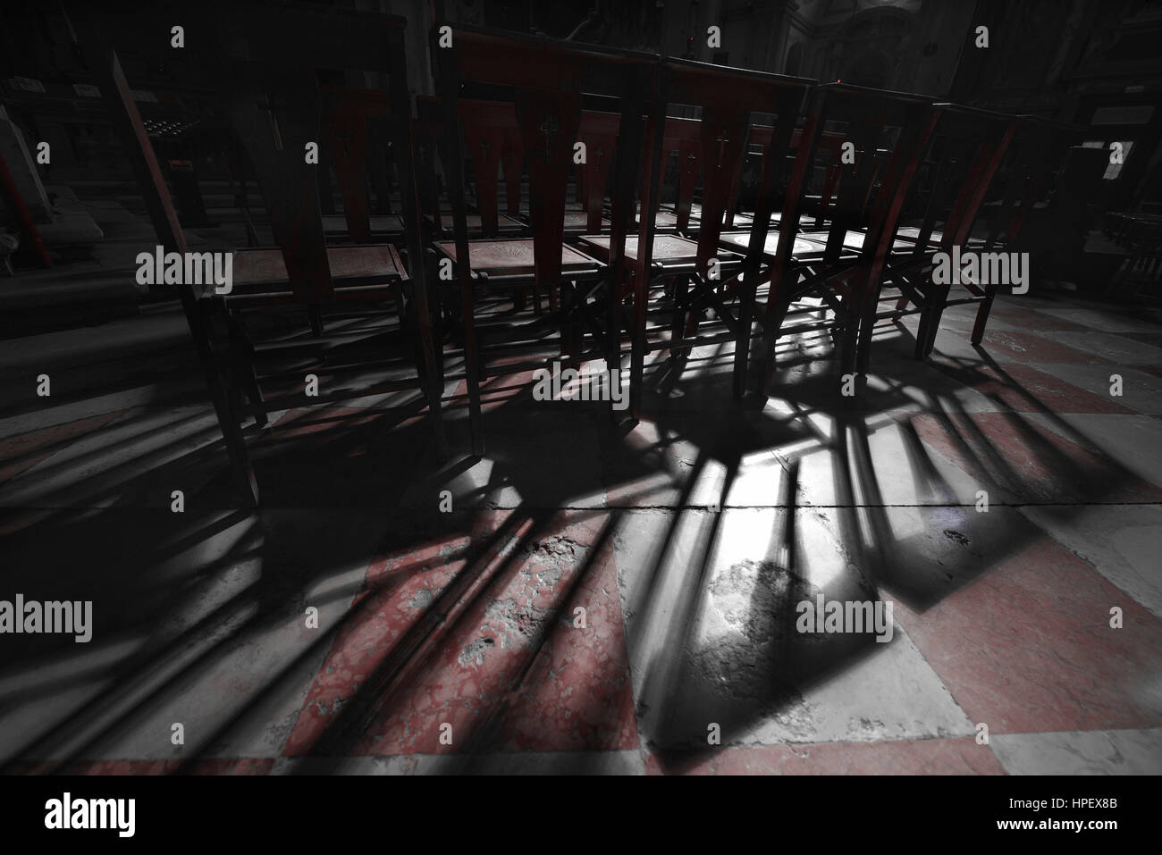 Gloomy lighting mood, chairs in a church cast their shadows on the ...