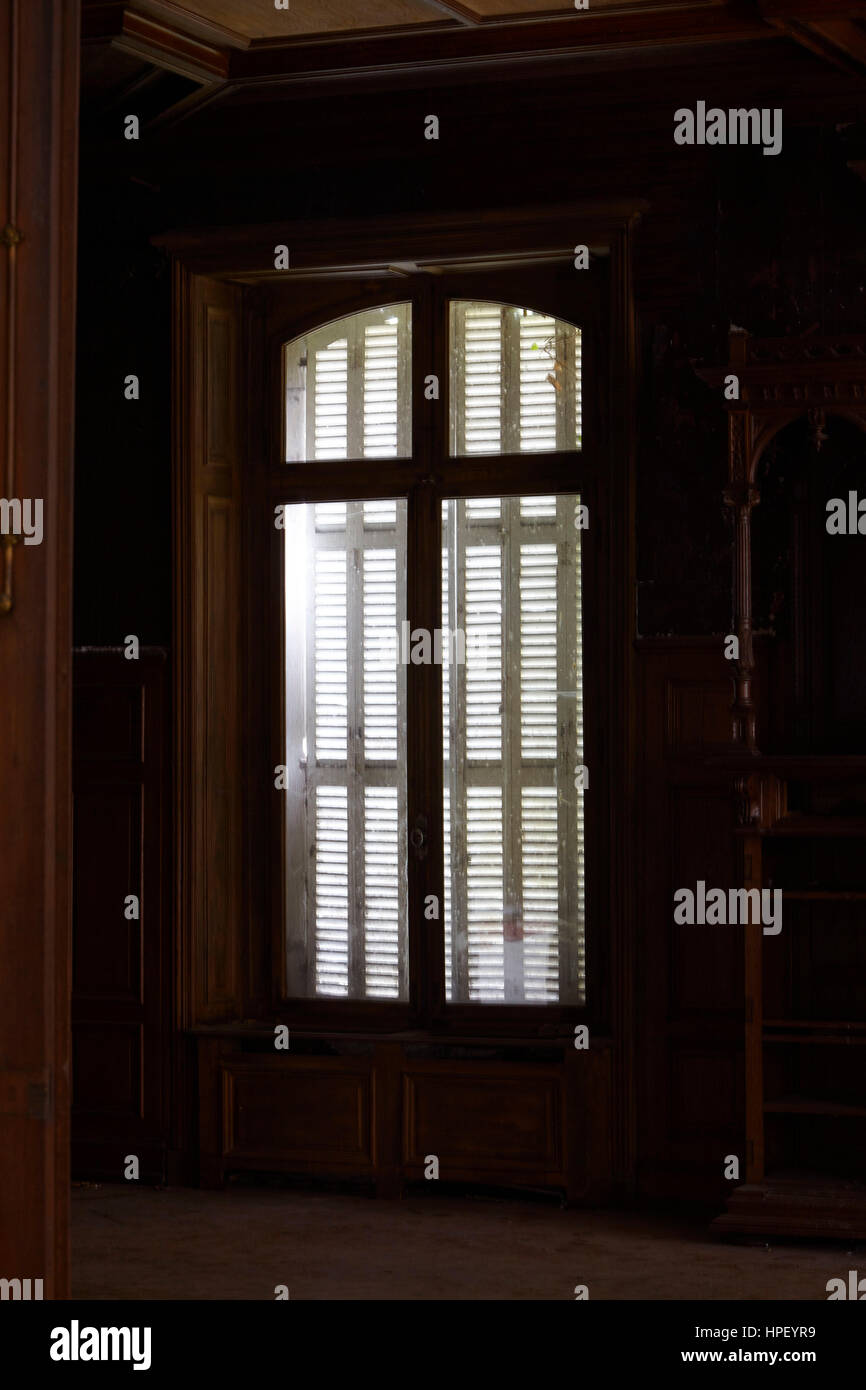 old window in a mansion with closed shutters against the sunlight Stock ...