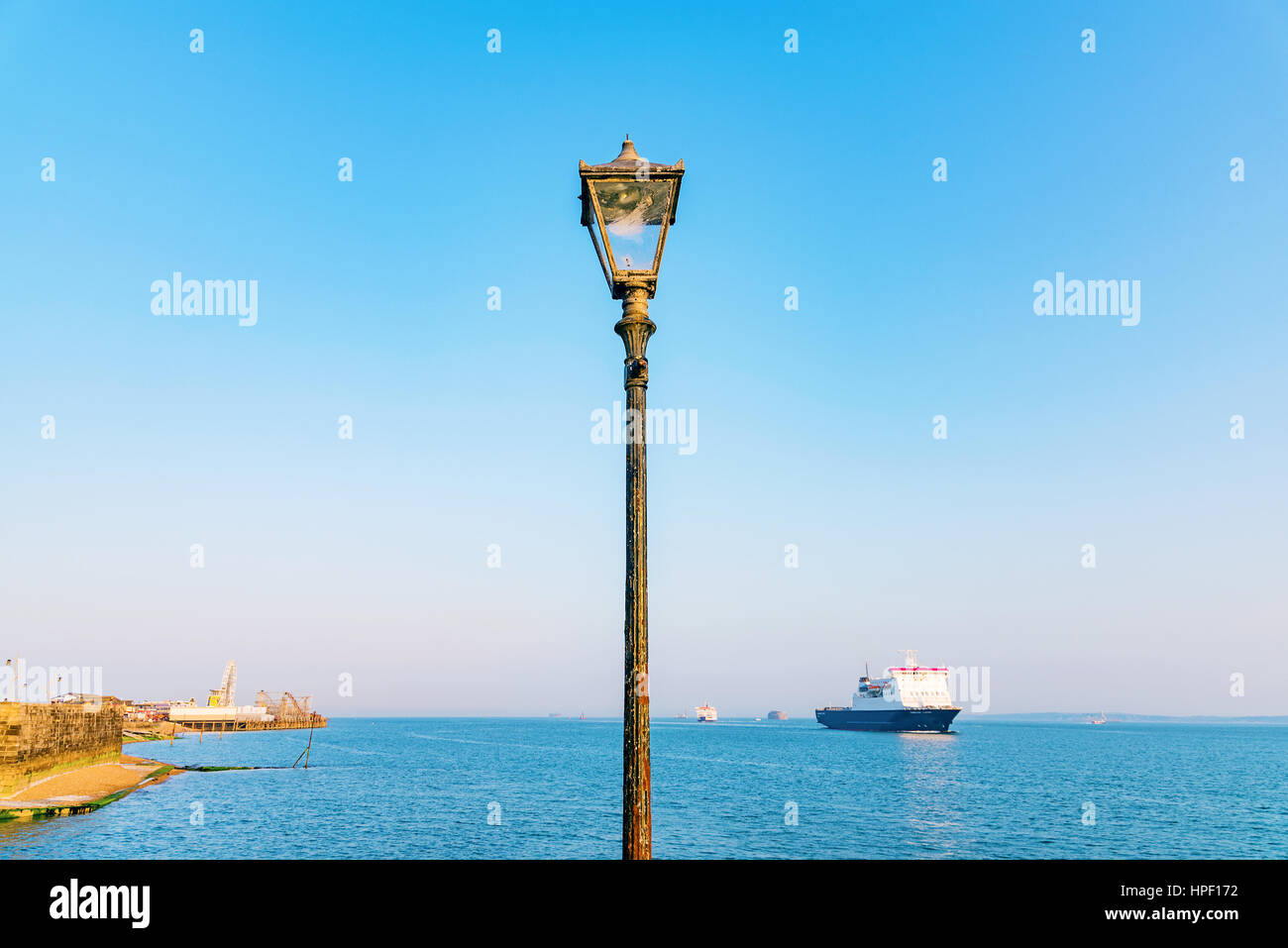 Lamp post with blue sky ocean and ship in the background Stock Photo ...