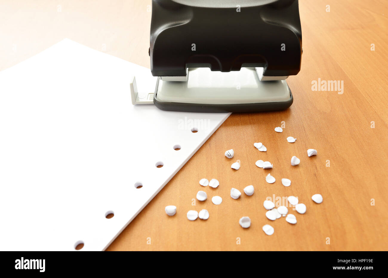Hole puncher with paper and confetti on wood office table Stock Photo ...