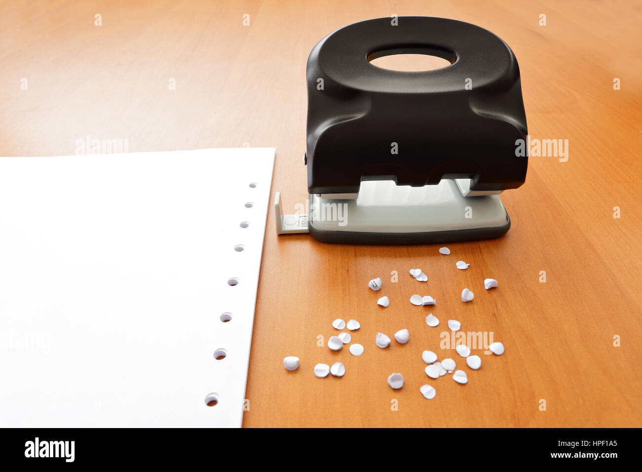 Hole puncher with paper and confetti on office table Stock Photo - Alamy