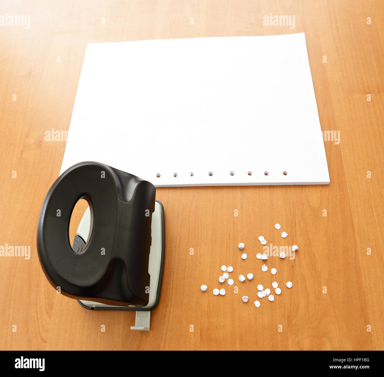 Hole puncher with paper and confetti on the office table Stock Photo ...