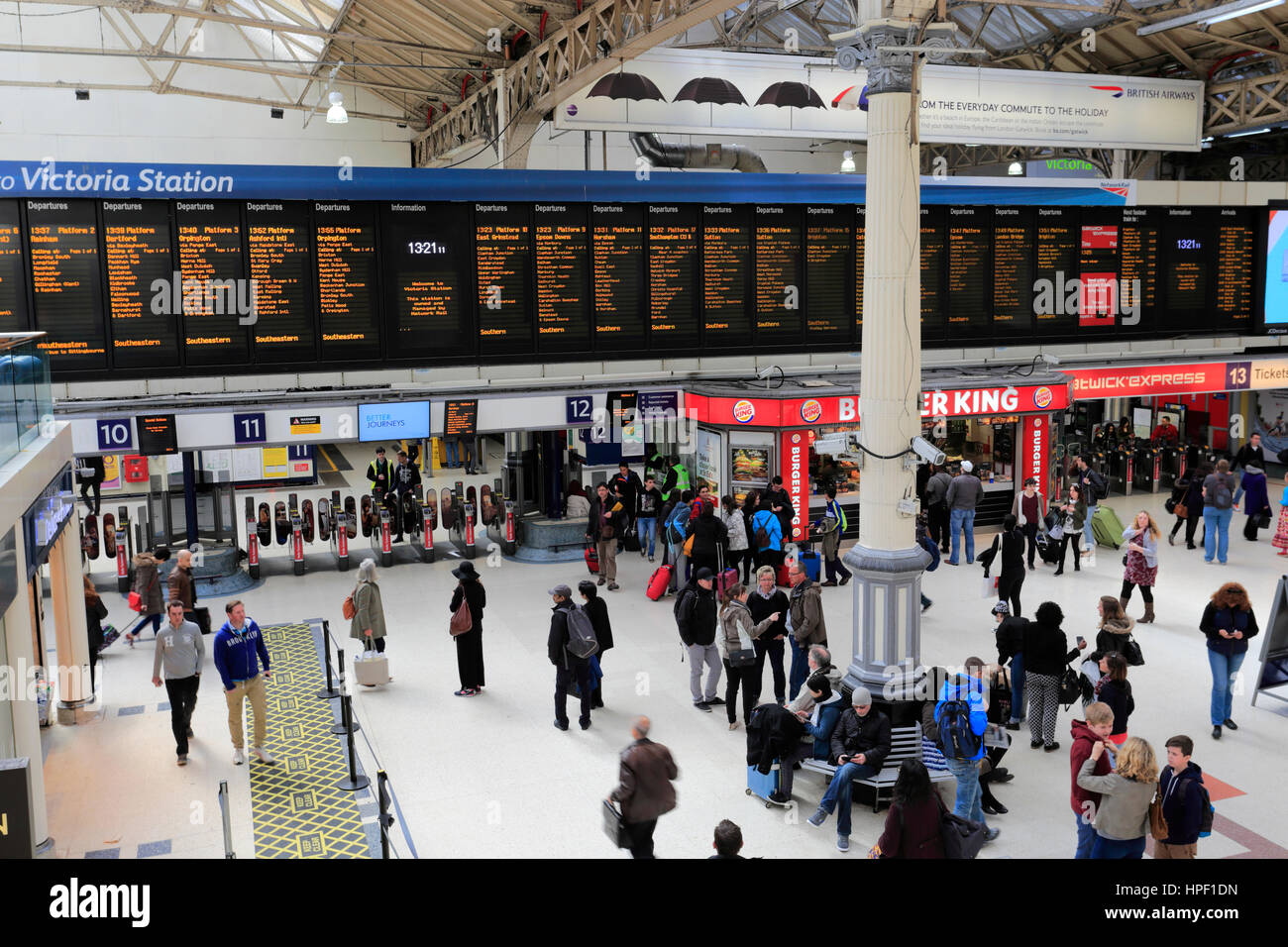People on the concourse and departure boards; Inside Victoria railway ...