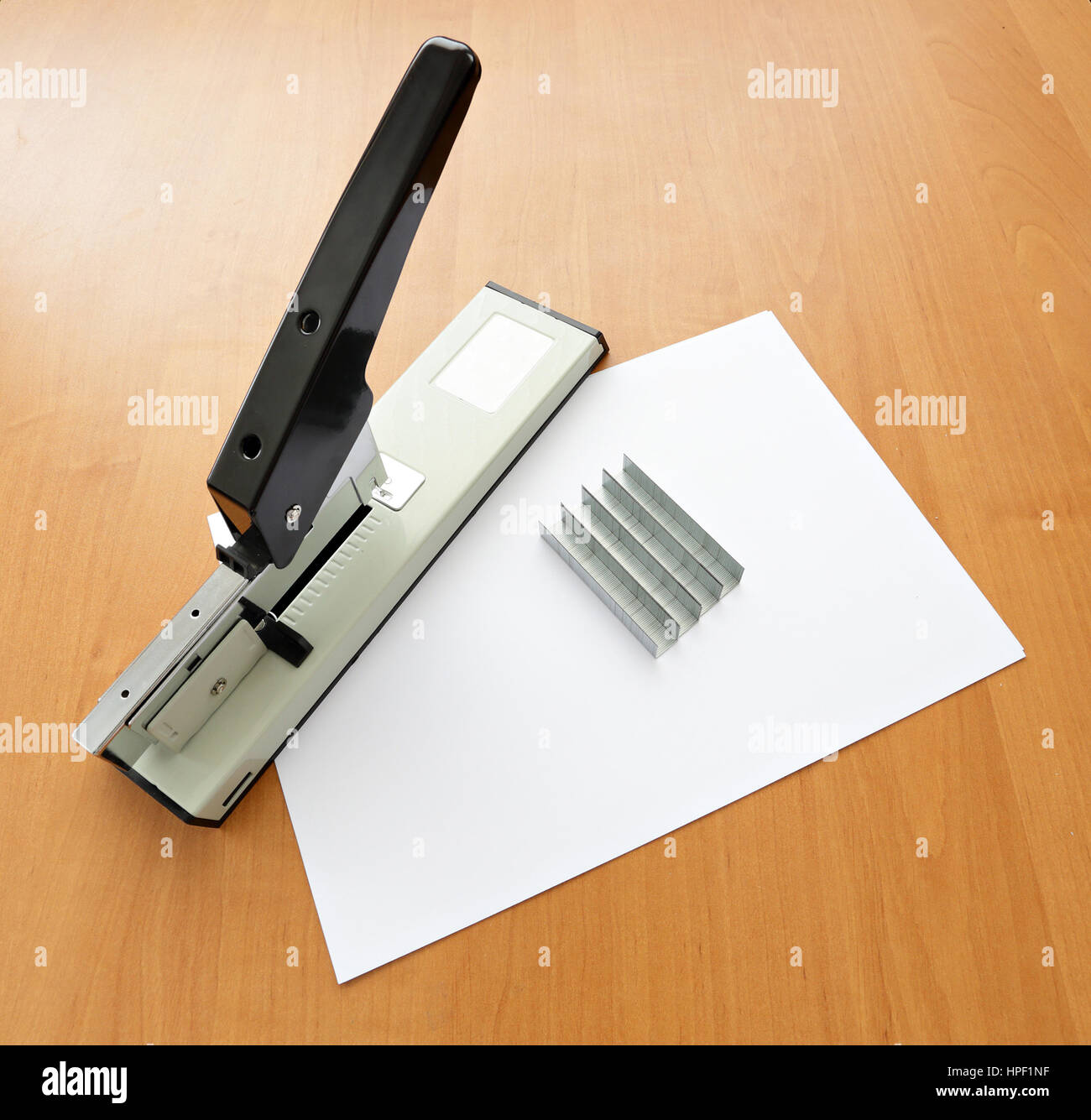 Stapler and staples with paper lay on wood table Stock Photo - Alamy