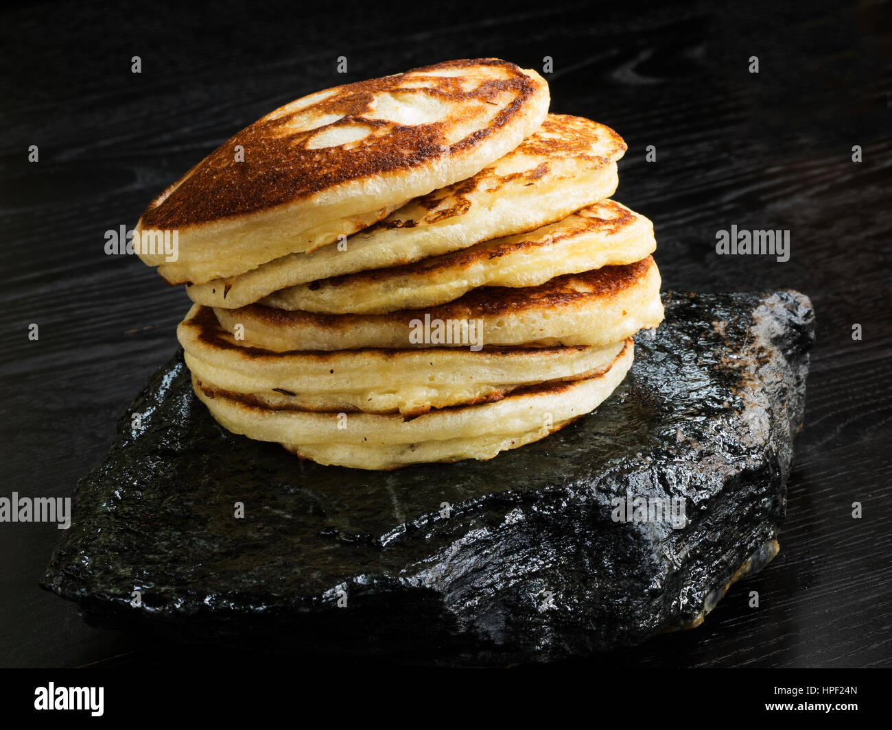 Pancakes on the black stone Stock Photo - Alamy