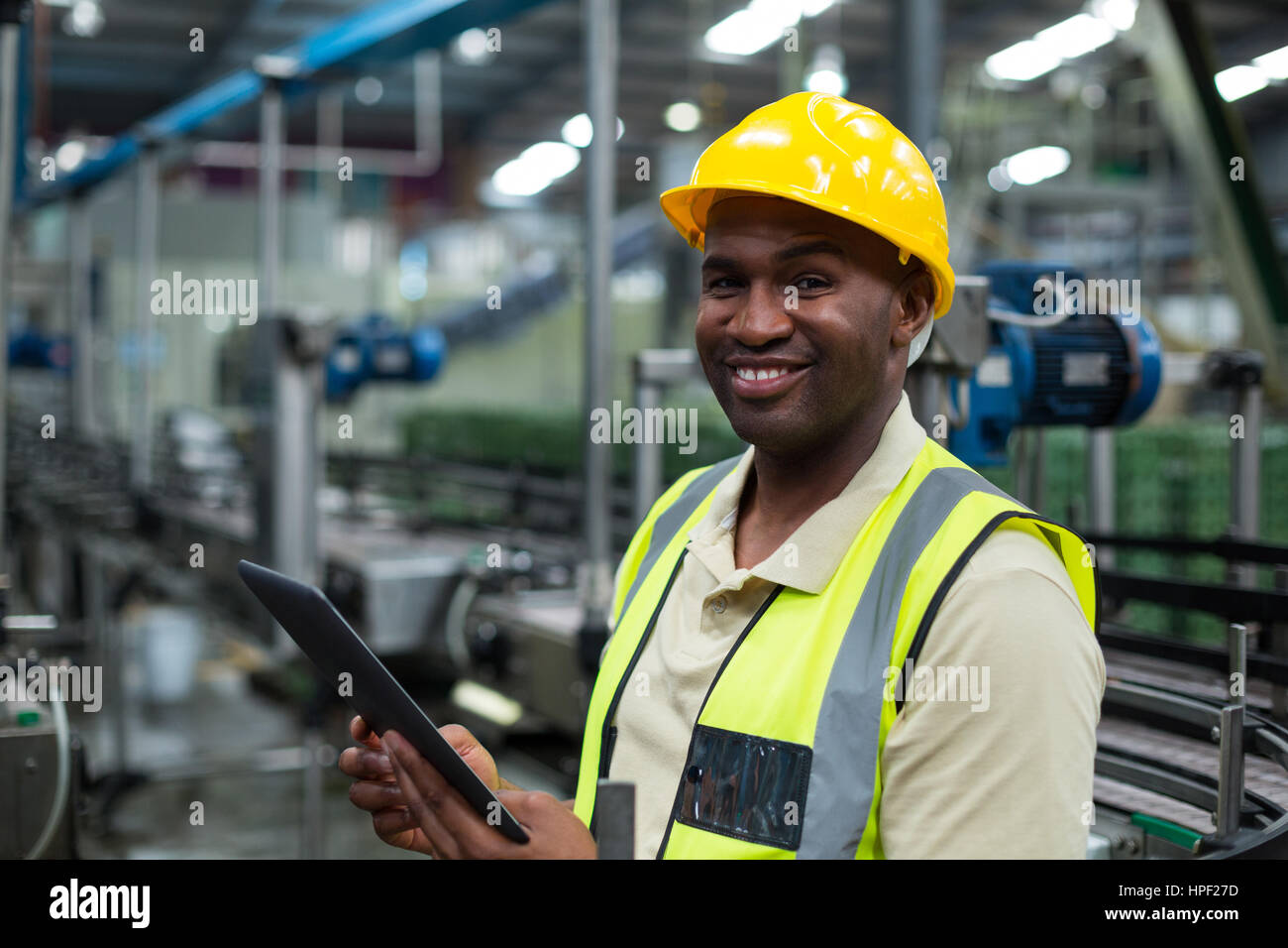 Portrait of smiling factory worker using a digital tablet in the ...