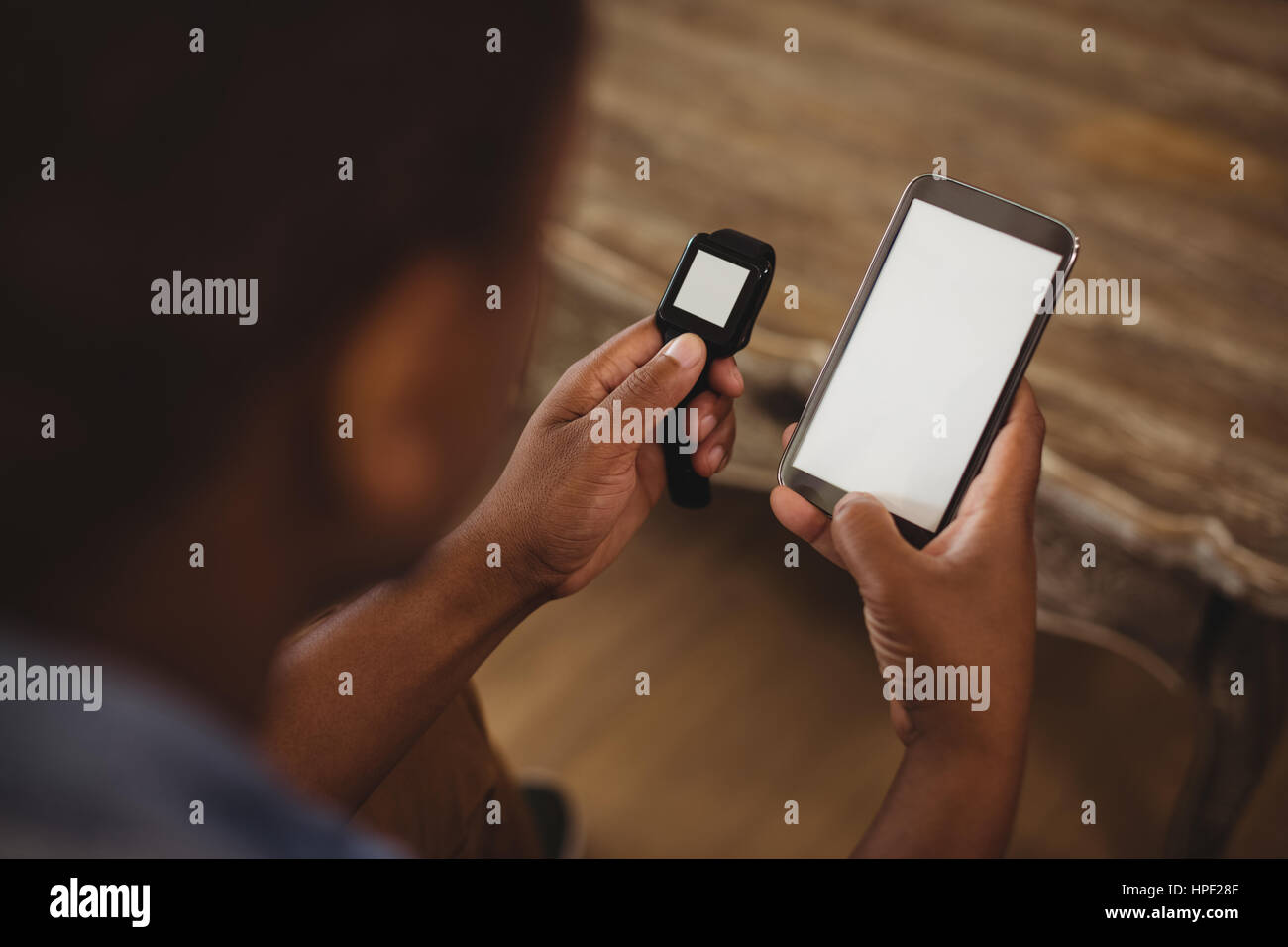 Man using smartwatch and smartphone at home Stock Photo - Alamy