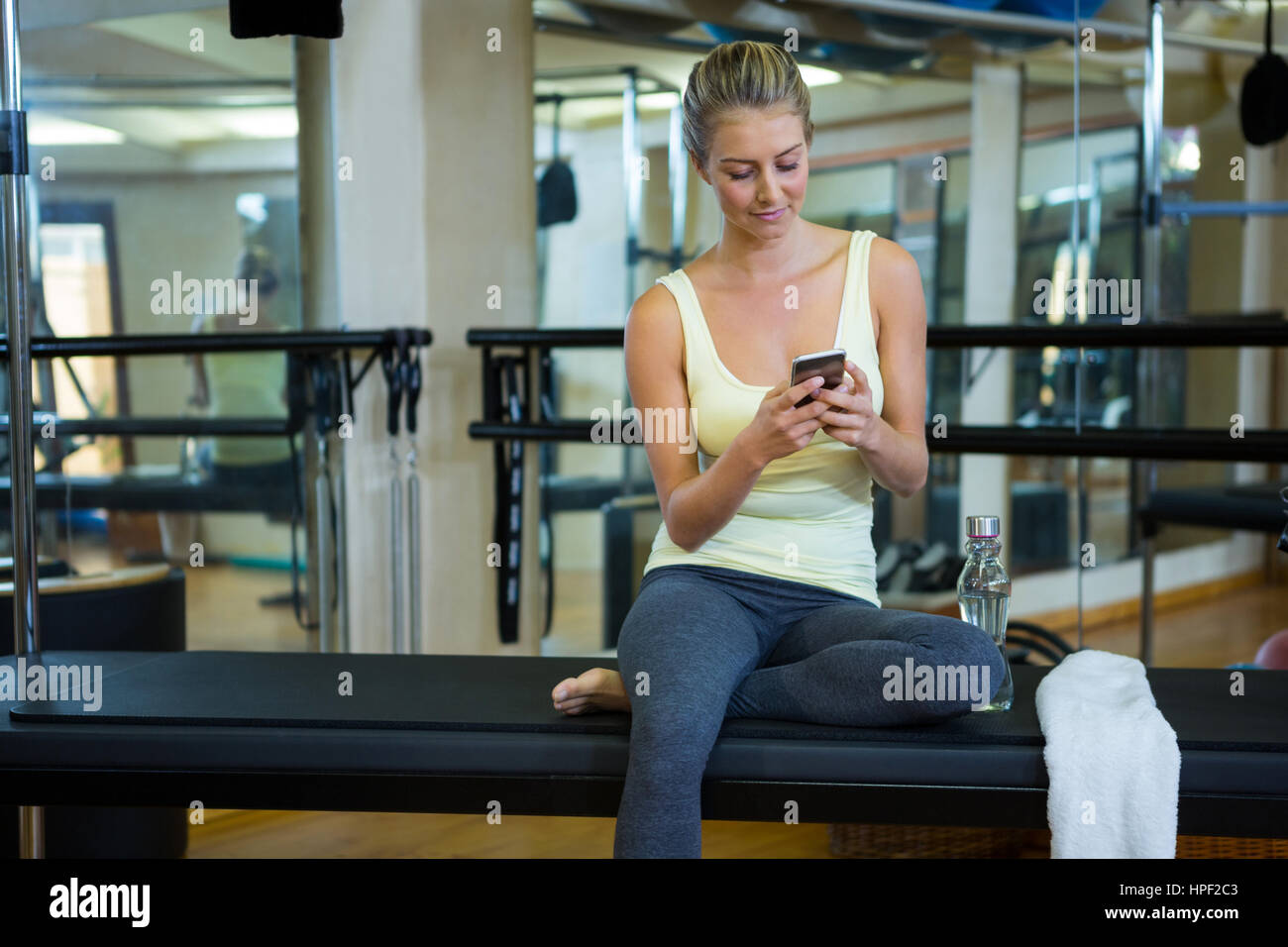 Beautiful fit woman using mobile phone after workout in gym Stock Photo ...