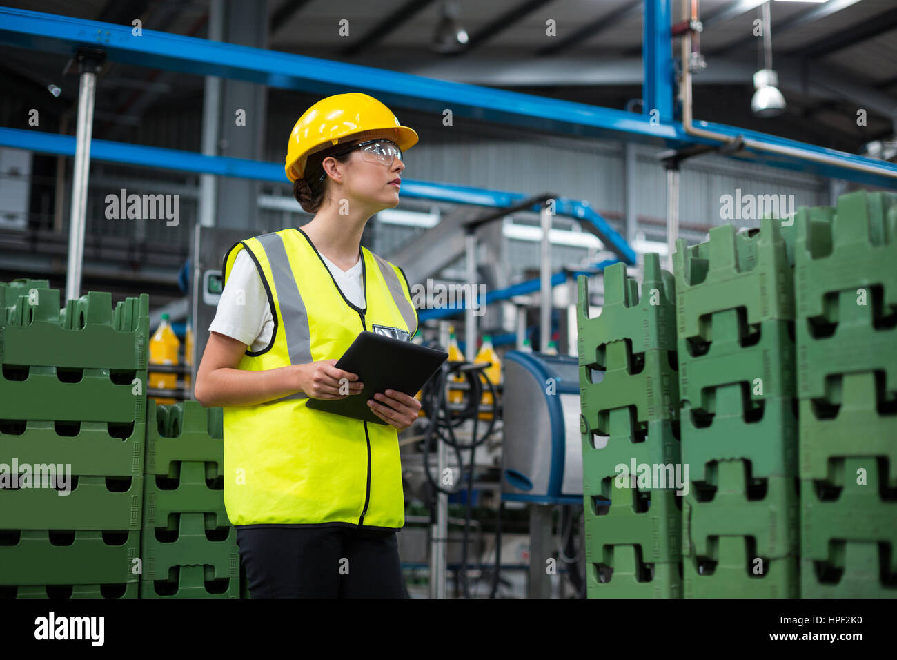 Female factory worker maintaining record on digital tablet in factory ...