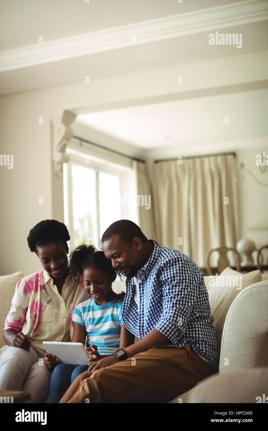 Family using digital tablet in living room at home Stock Photo - Alamy