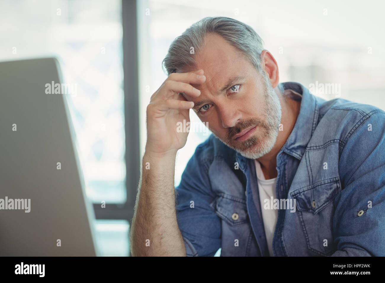 Portrait of worried male executive sitting in office Stock Photo - Alamy