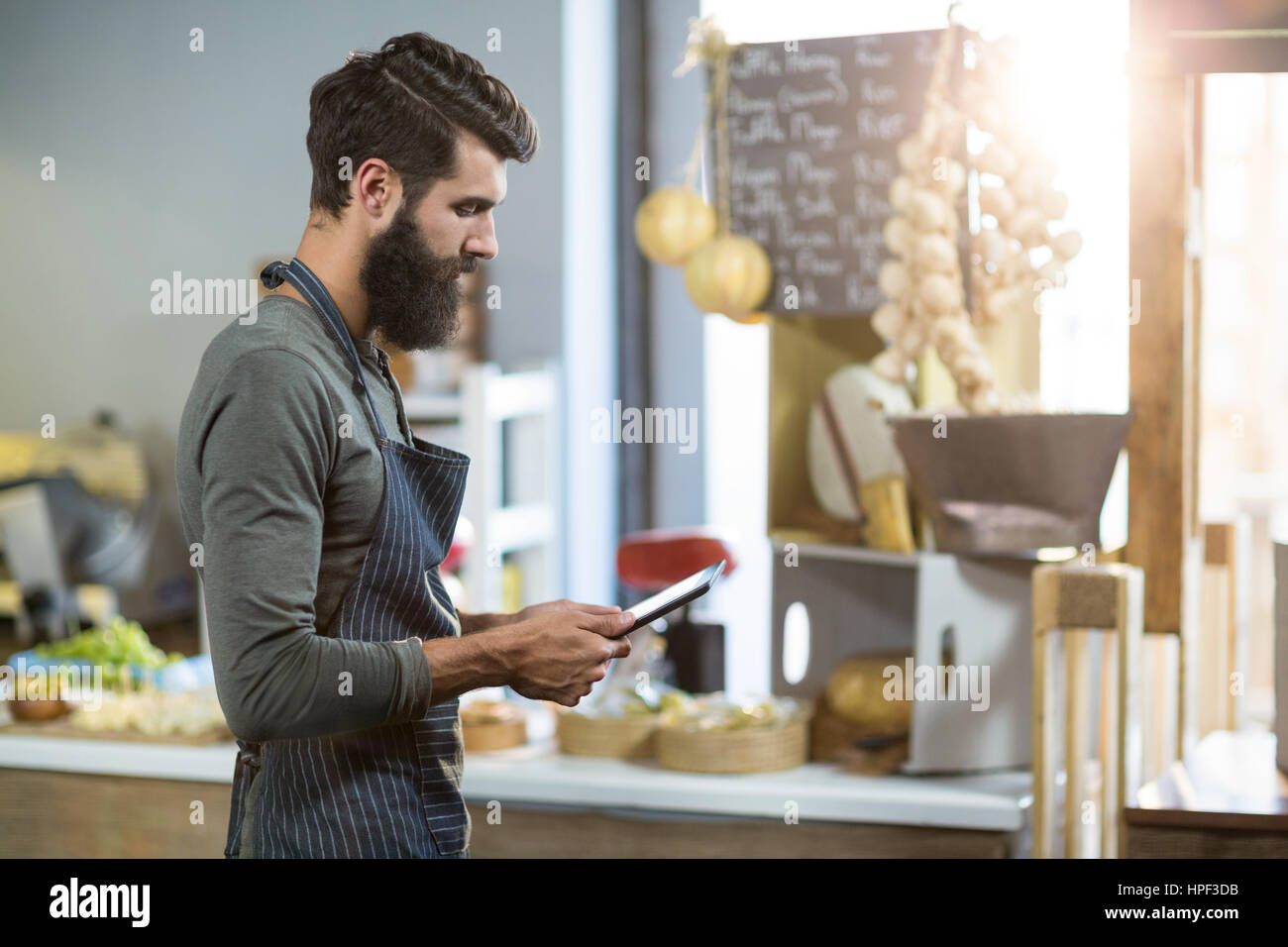 Salesman using digital tablet at counter in grocery shop Stock Photo ...