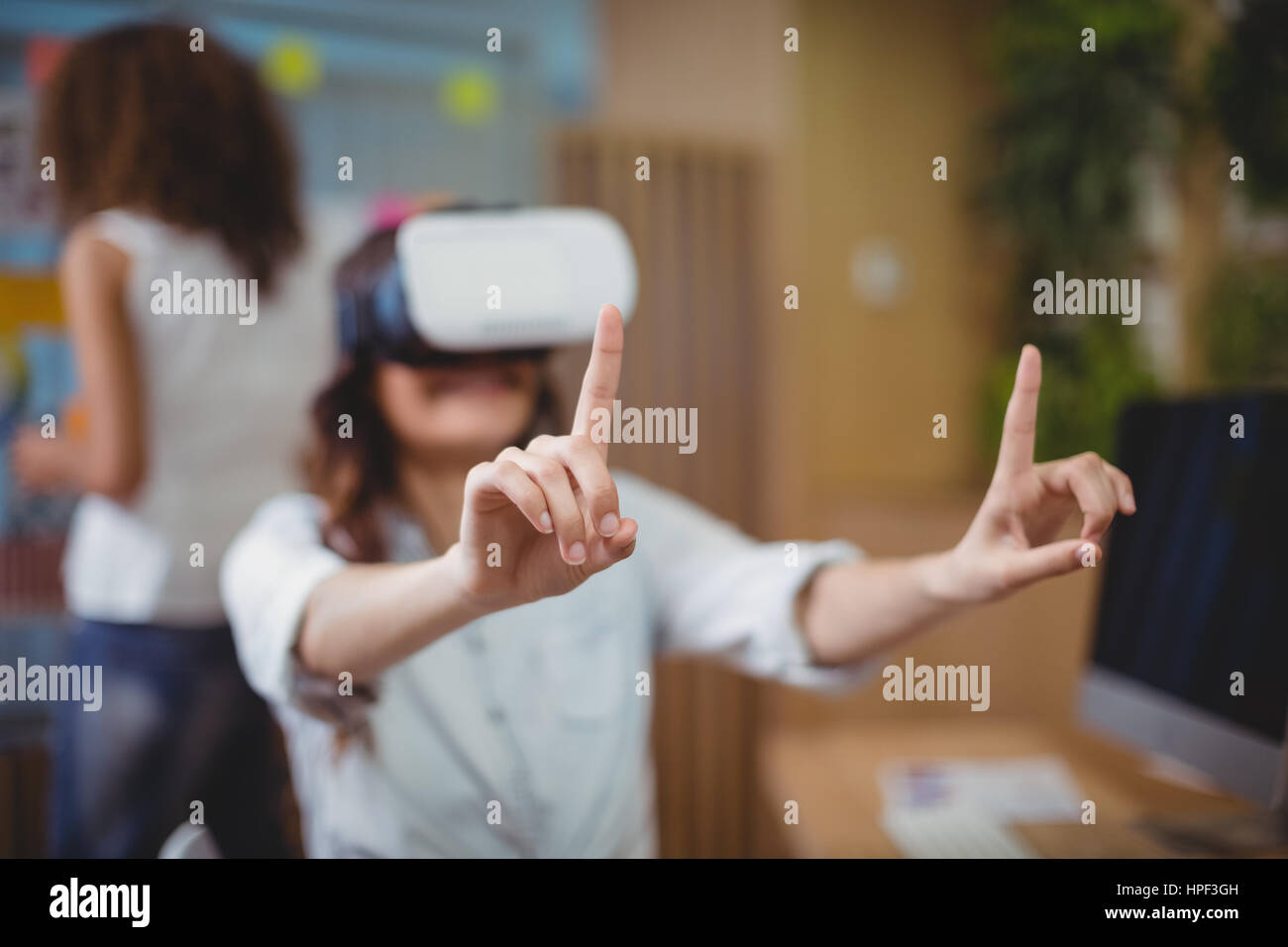 Female business executive using virtual reality headset in office Stock ...