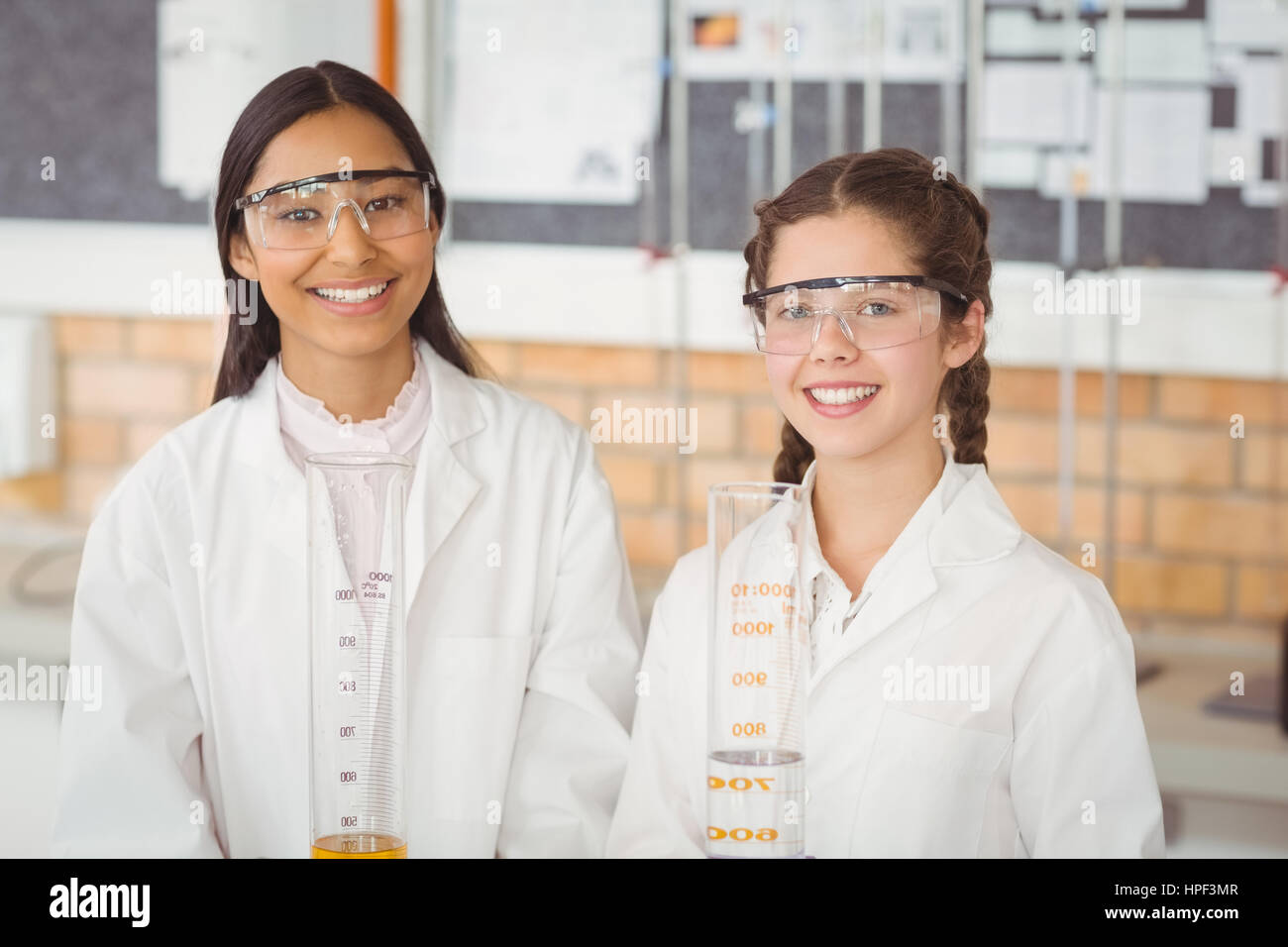Portrait of smiling schoolgirls standing in laboratory at school Stock ...