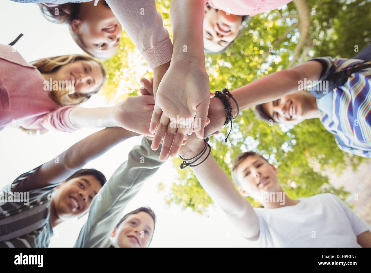 Happy school kids forming hand stack in campus at school Stock Photo ...