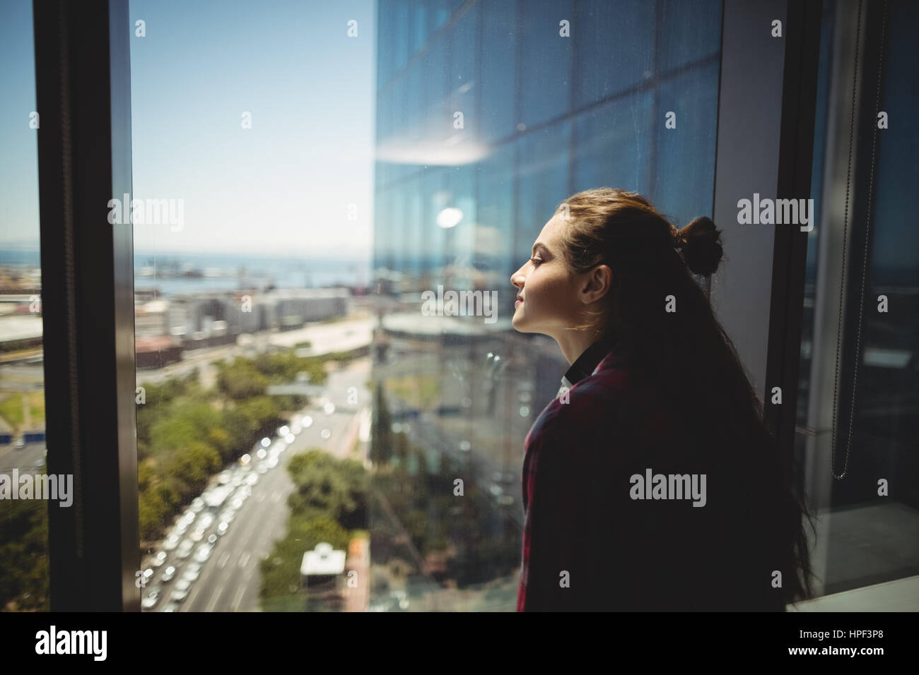 Female graphic designer looking through window in office Stock Photo ...