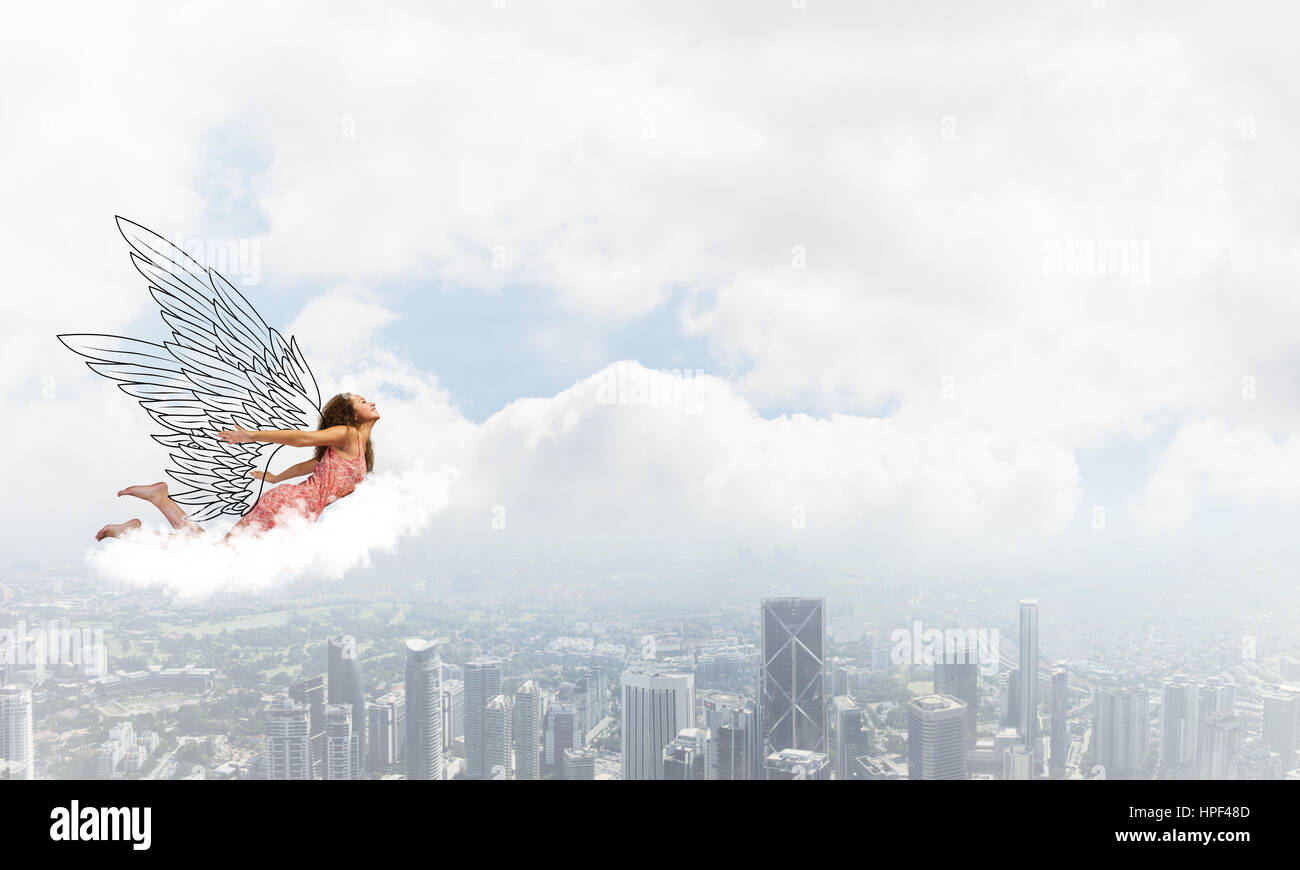 Young woman flying high in blue sky Stock Photo - Alamy