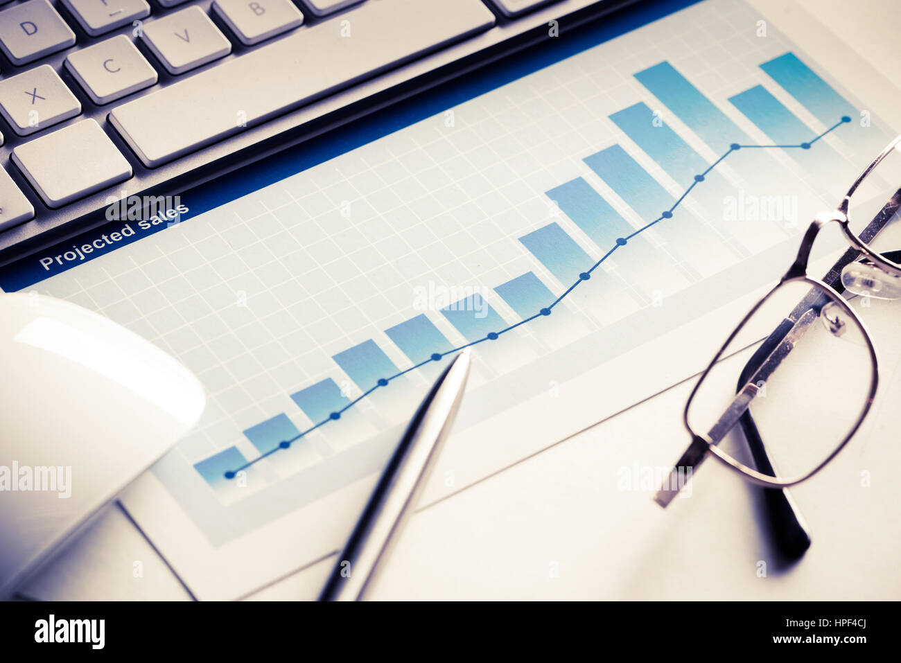 Business workplace with keyboard mouse and papers with graphs and ...