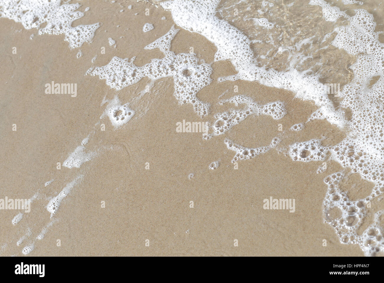 Sea foam with bubbles on sand background Stock Photo - Alamy