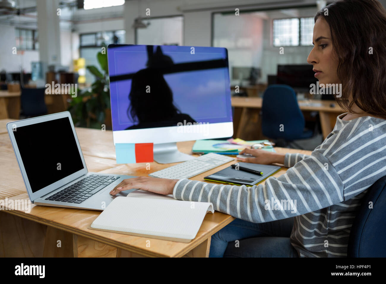 Female graphic designer working at desk in creative office Stock Photo ...