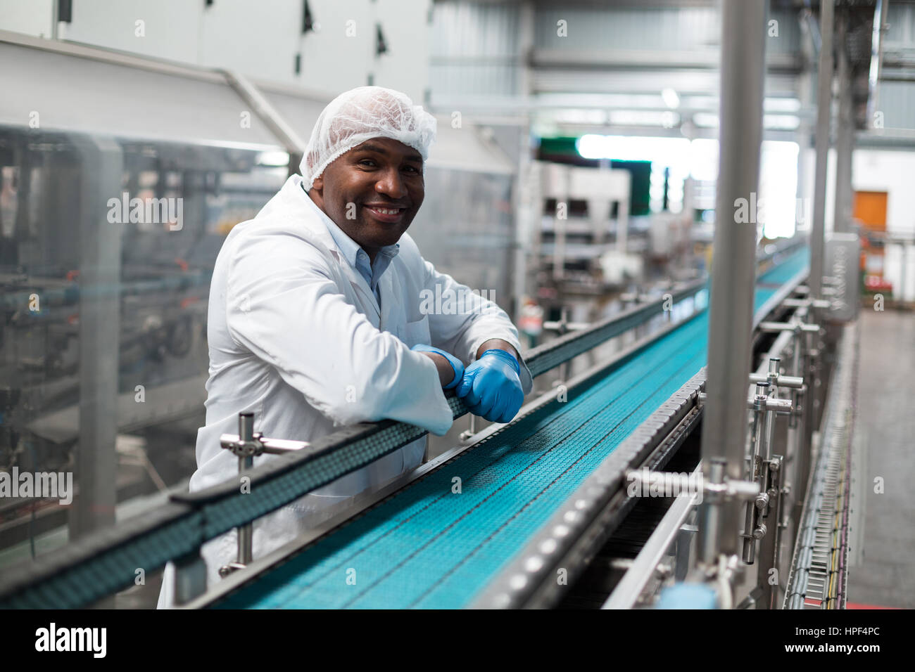 Portrait of factory engineer leaning on production line in drinks ...