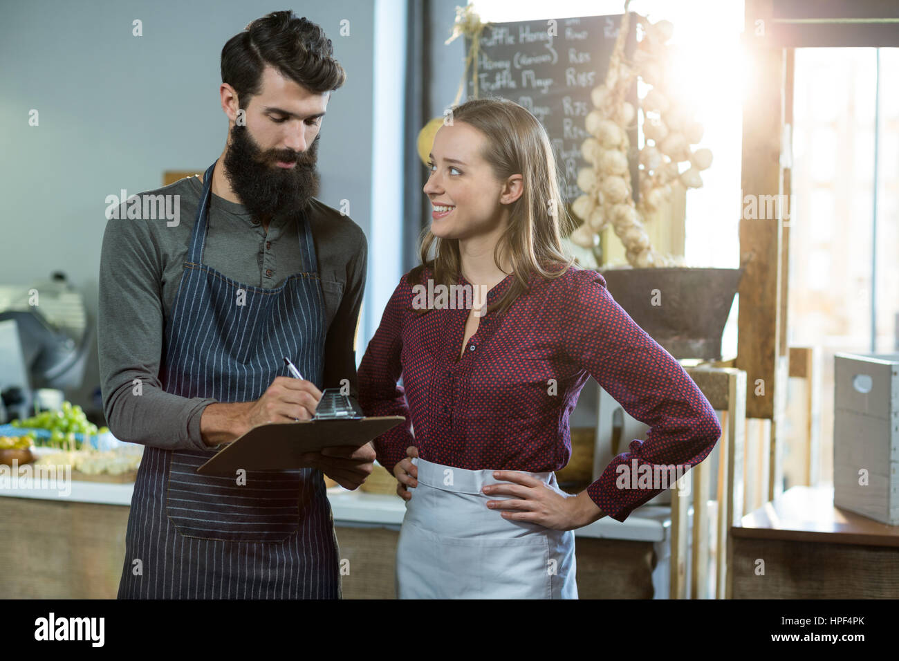 Smiling bakery staff writing on clipboard at counter in bake shop Stock ...