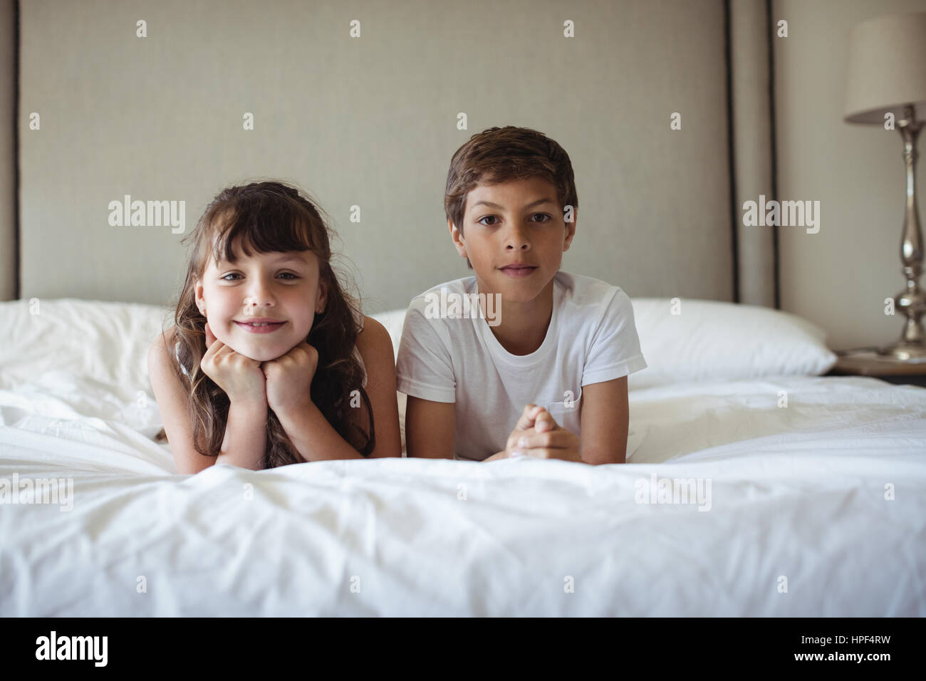 Siblings smiling in bed at home Stock Photo - Alamy