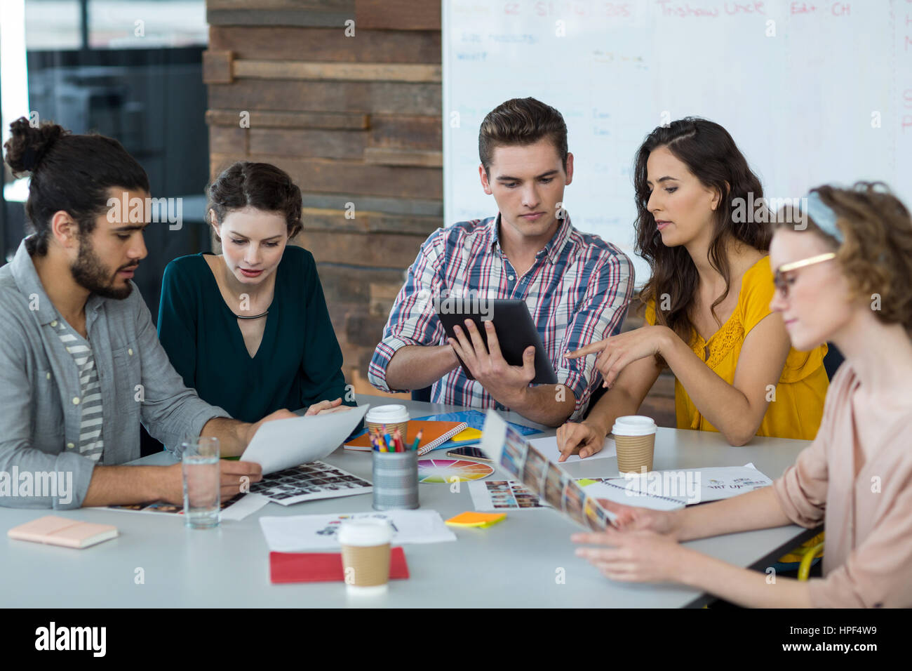 Graphic designers working together in office Stock Photo - Alamy