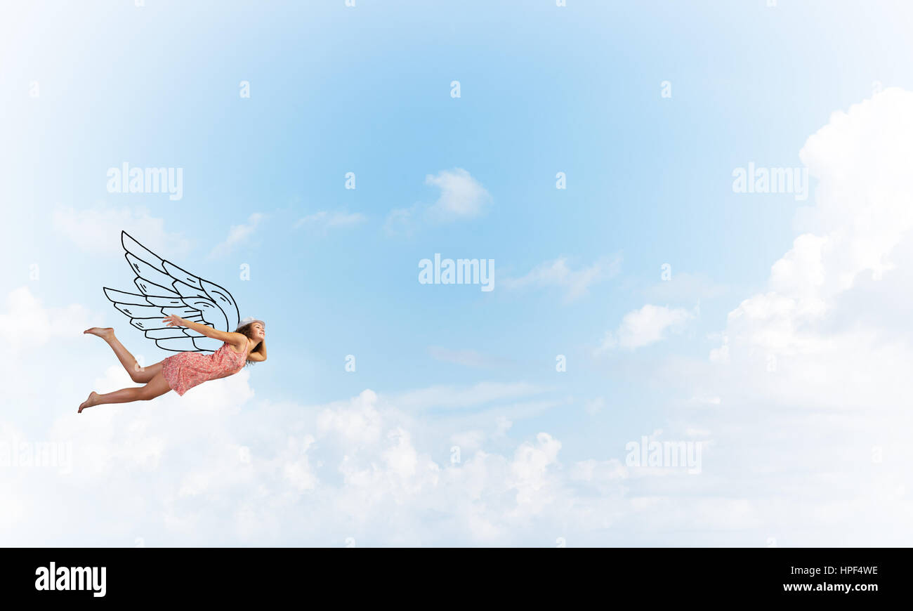 Young woman flying high in blue sky Stock Photo - Alamy