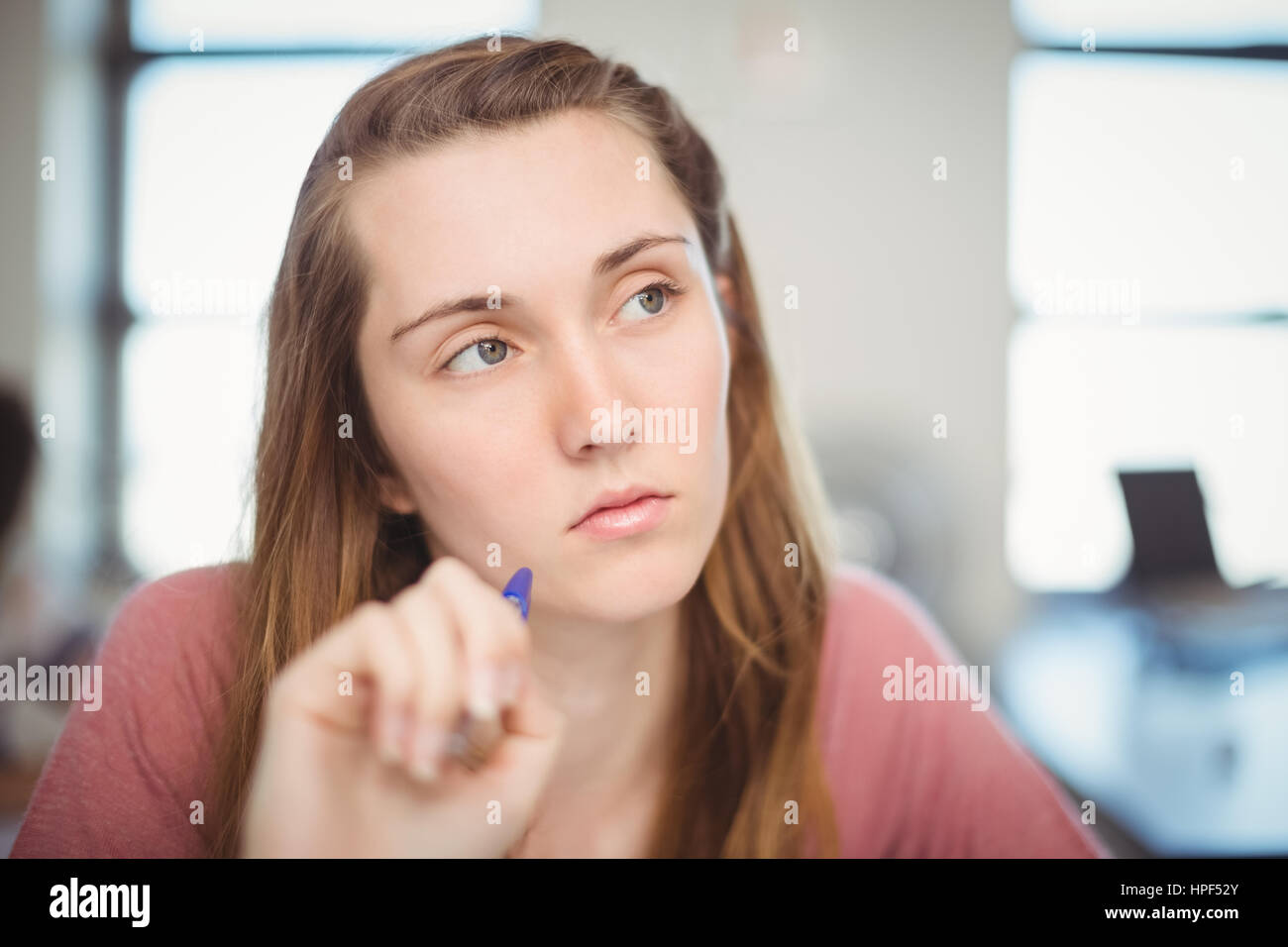 Thoughtful school girl doing homework in classroom at school Stock ...