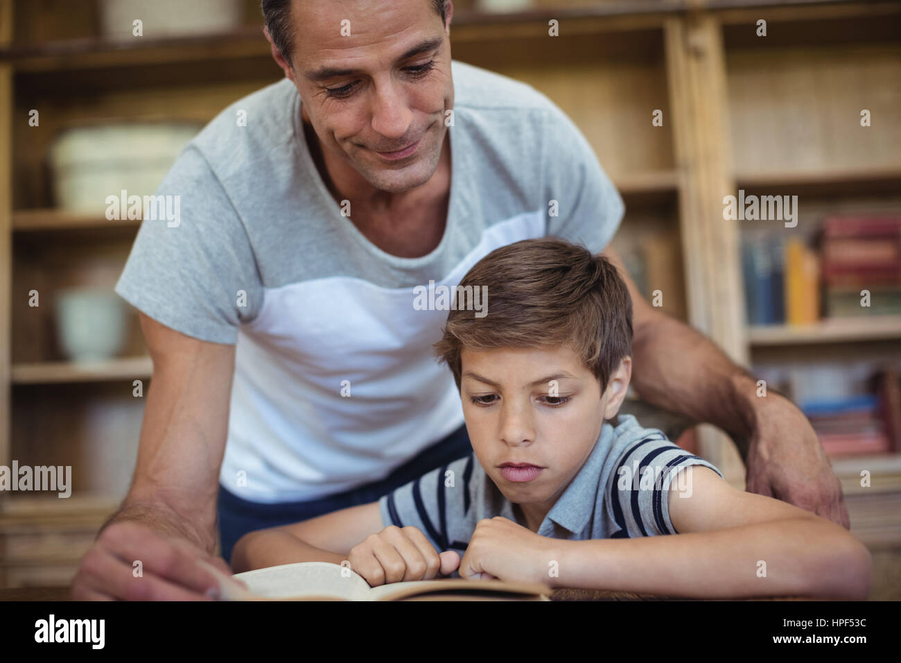 Father and son reading a book in study room at home Stock Photo - Alamy