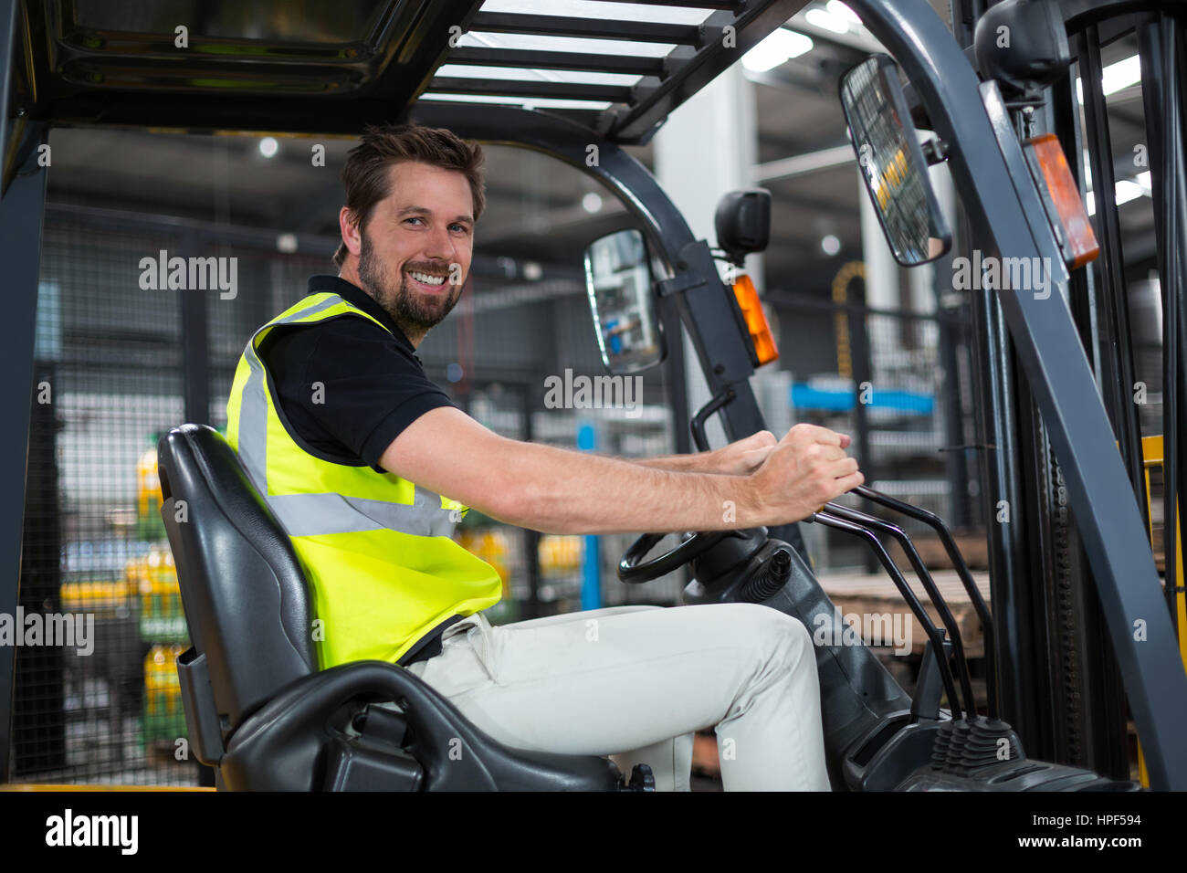 Portrait of smiling factory worker driving forklift in factory Stock ...